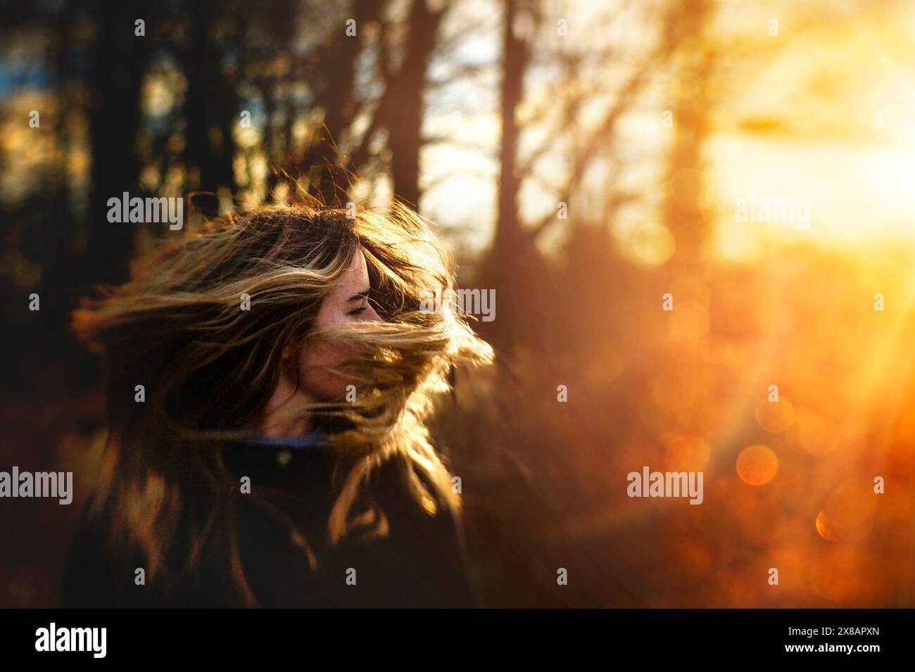 Beautiful teen girl flipping hair in golden sunlight Stock Photo - Alamy