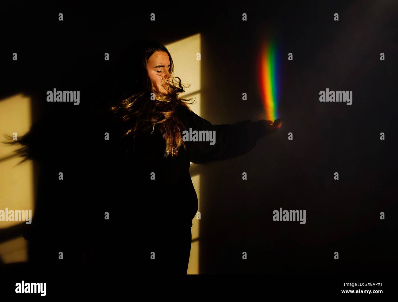 Beautiful teen holding rainbow in sun and shadows Stock Photo - Alamy