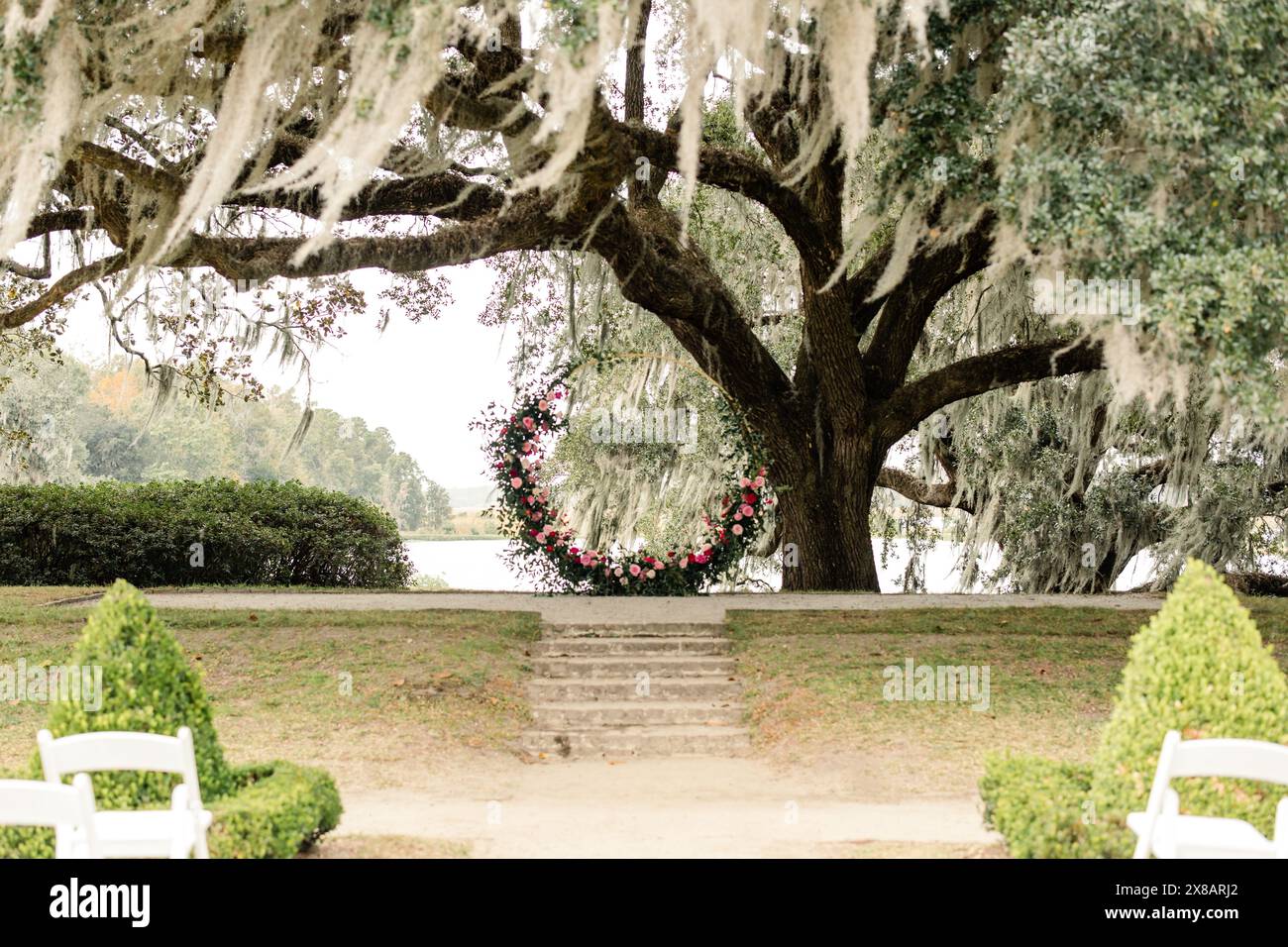 Outdoor wedding ceremony setup with a floral arch under oak tree Stock ...