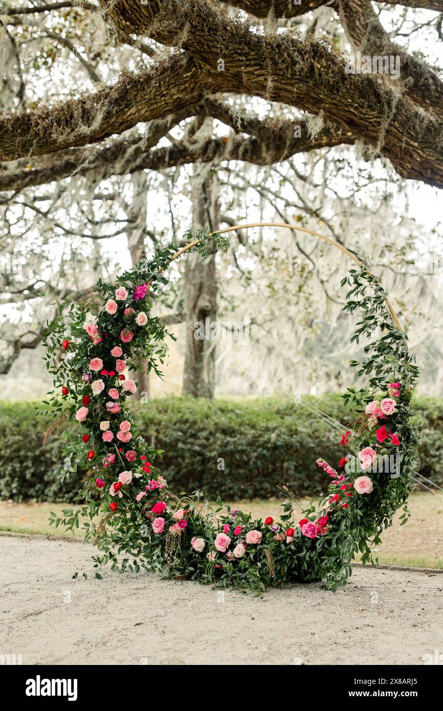 Circular floral arrangement with pink and red flowers under a tree ...