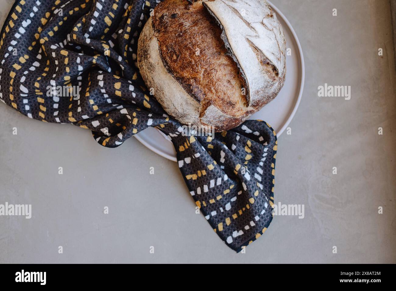Rustic loaf of bread on a plate with a patterned cloth Stock Photo - Alamy