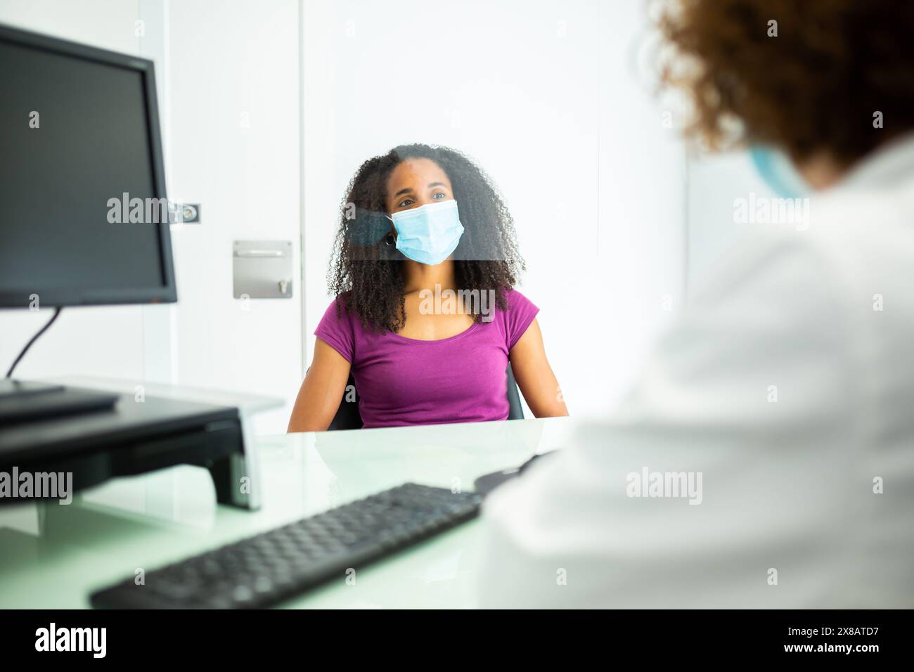 Patient wearing blue surgical masks at the doctor's office, having a ...