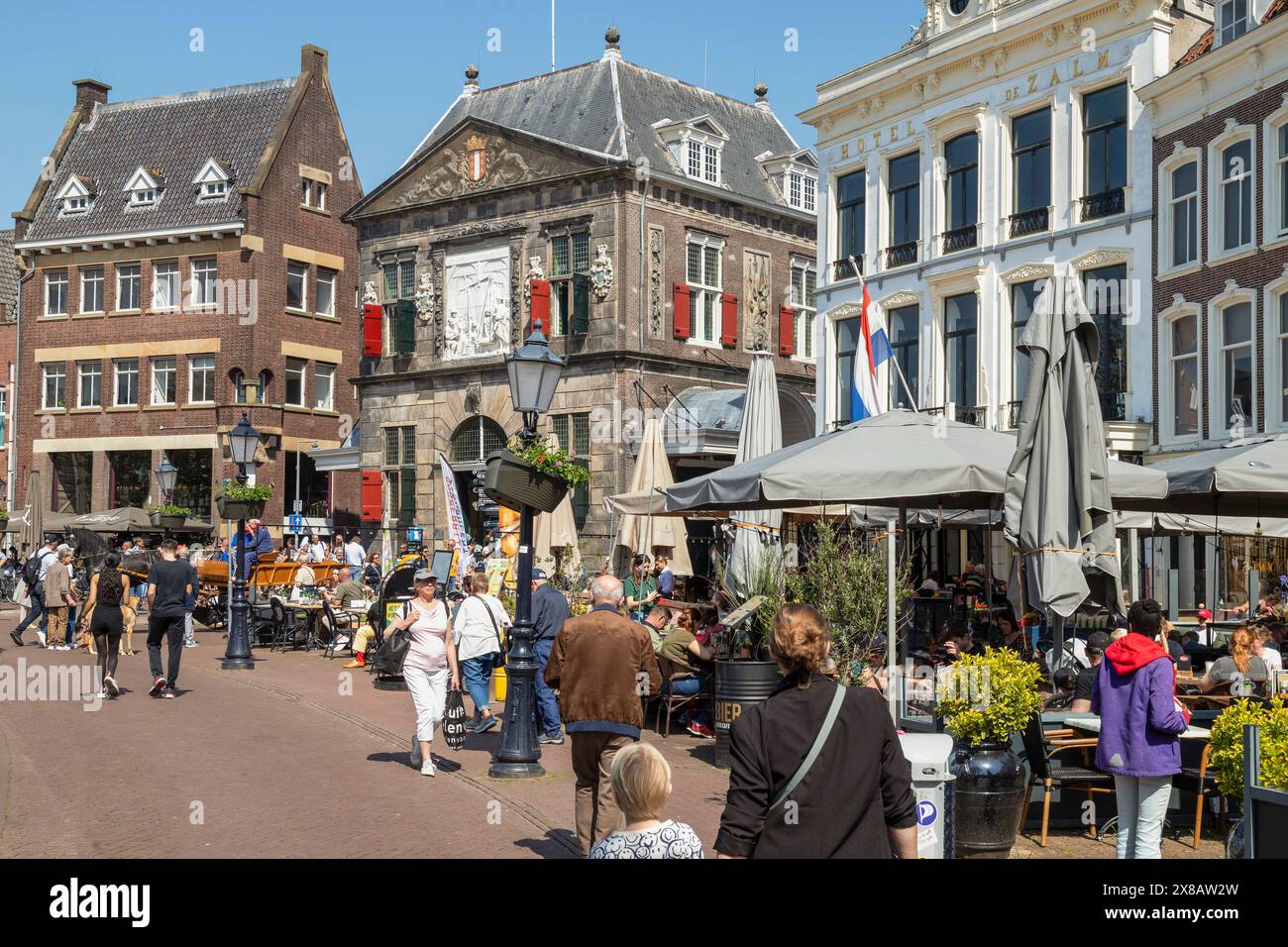 People walk past the historic buildings on the market square in the ...
