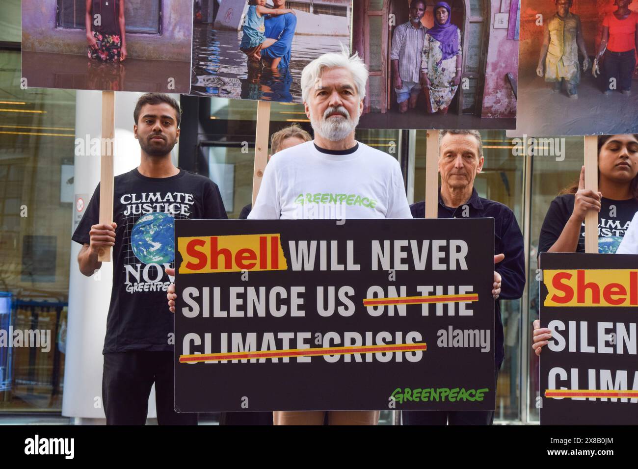 London, UK. 24th May 2024. Greenpeace activists stand with placards and ...