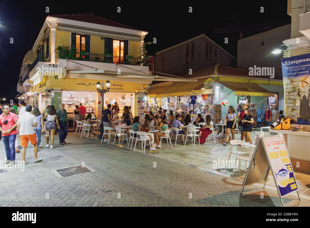 Lefkada, Greece night view of a pedestrian area with shops and crowd in ...