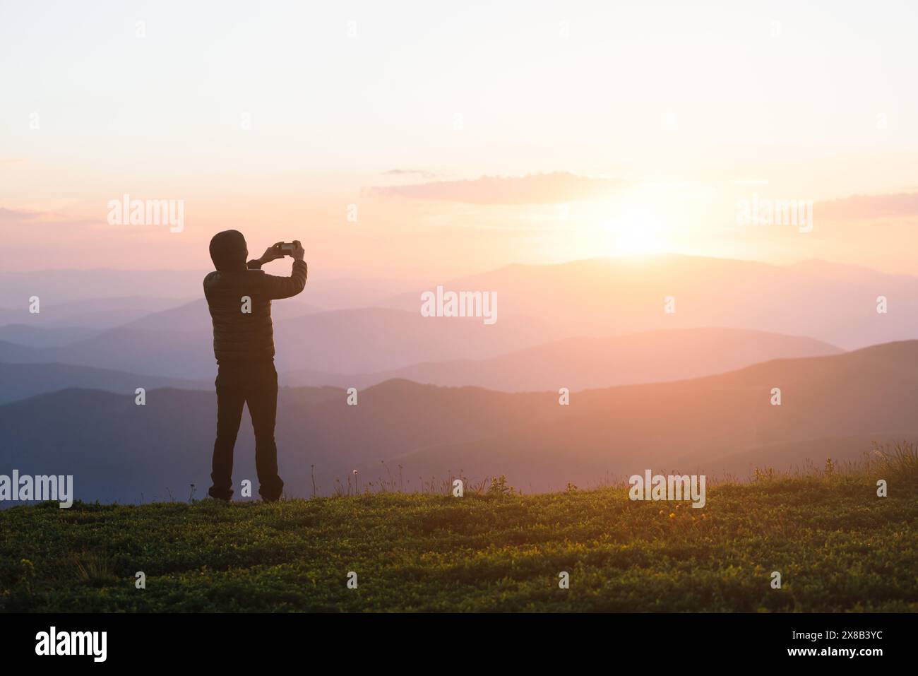 Tourist Capturing Mountain Sunset on Phone Stock Photo - Alamy