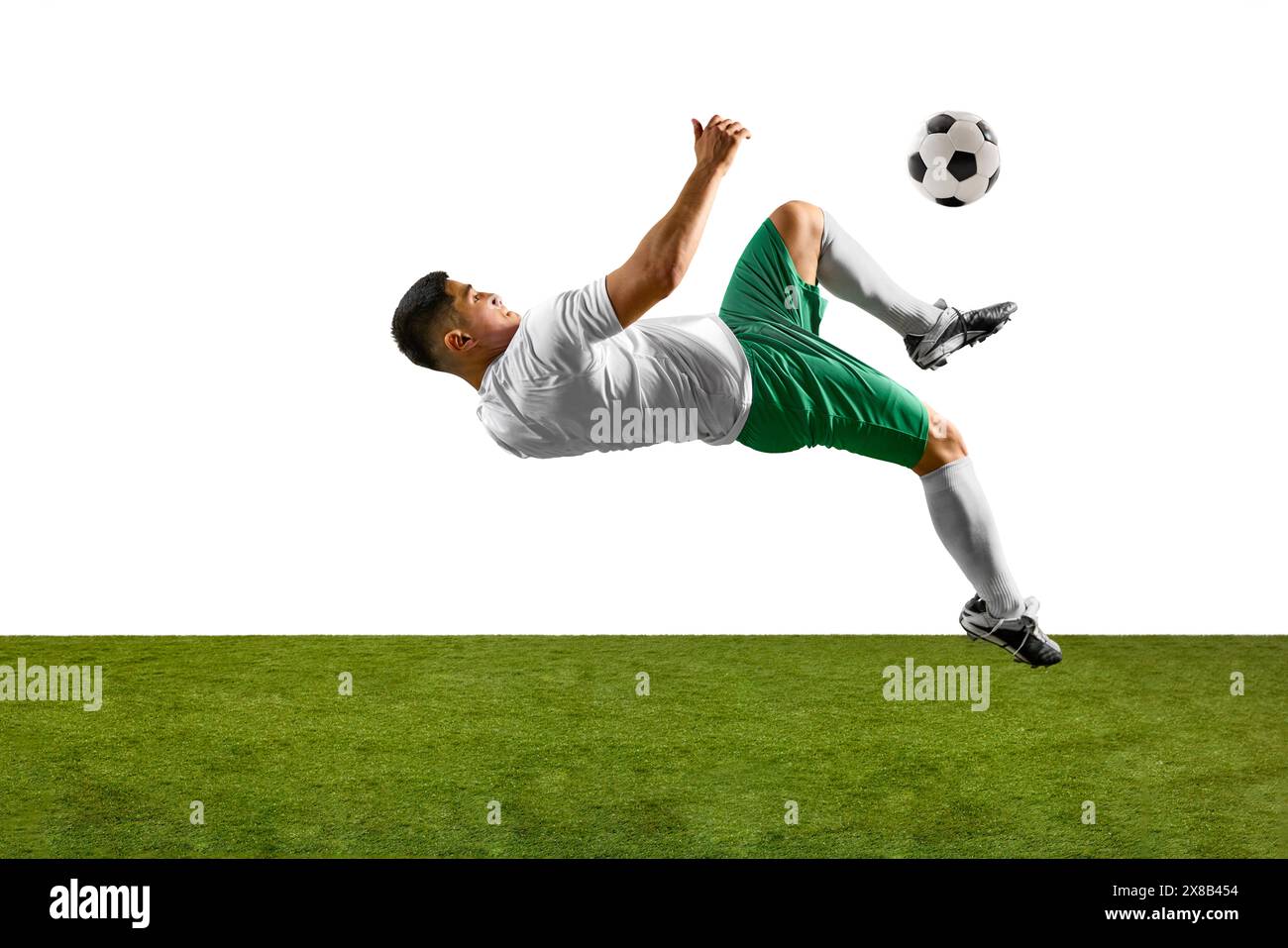 Side view of soccer player performing acrobatic kick with soccer ball ...