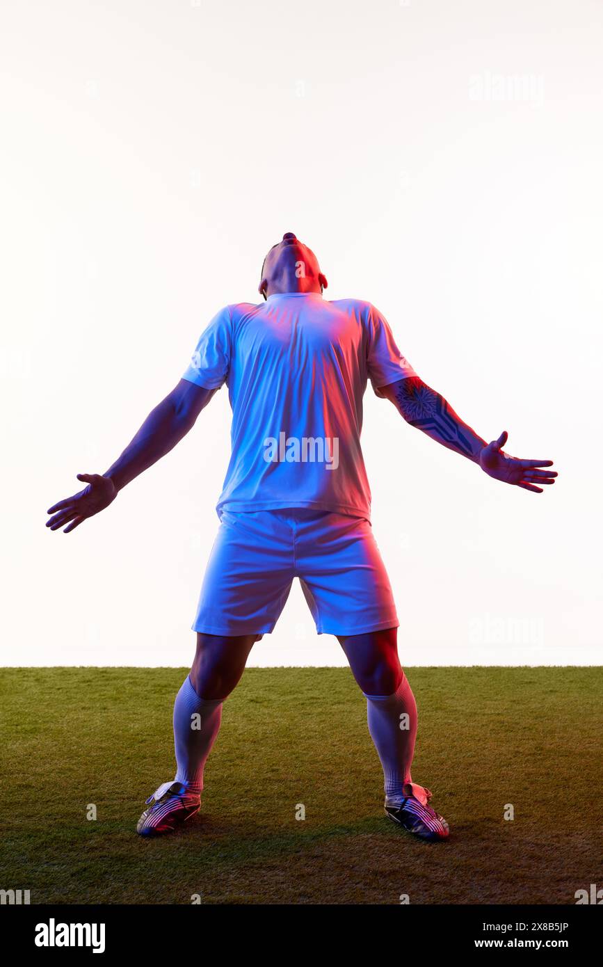 Champion. Football player with arms wide open leaned back freezing in ...