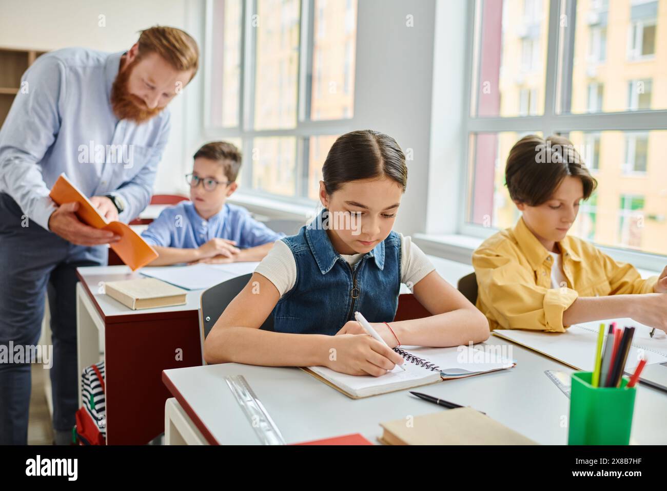 A group of children engage in learning activities, seated at bright ...