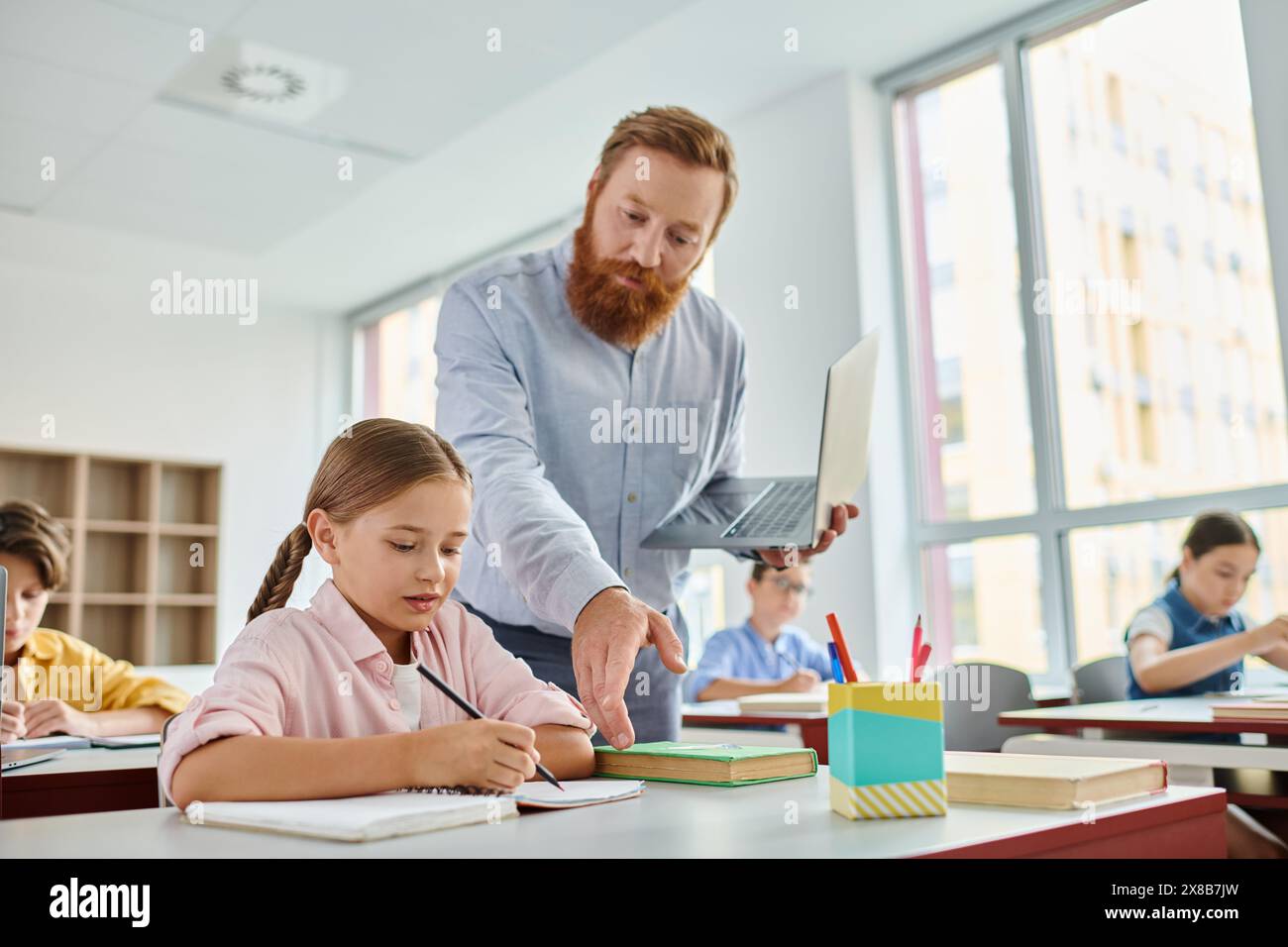 A male teacher assists a young girl with her homework in a vibrant ...