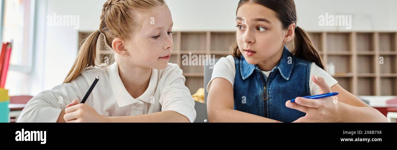 Two girls with pens in hand, focused and engaged in a creative task at ...