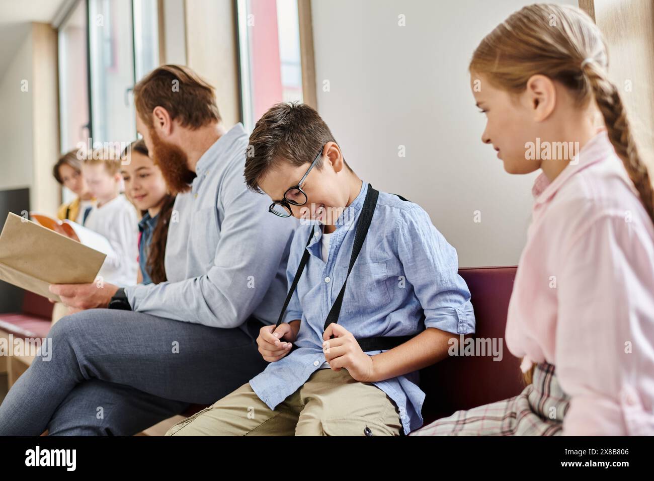In a bright, lively classroom, a man teacher instructs a diverse group ...