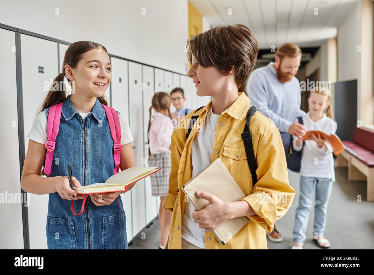 A boy and girl, part of a diverse group of kids, stand next to each ...