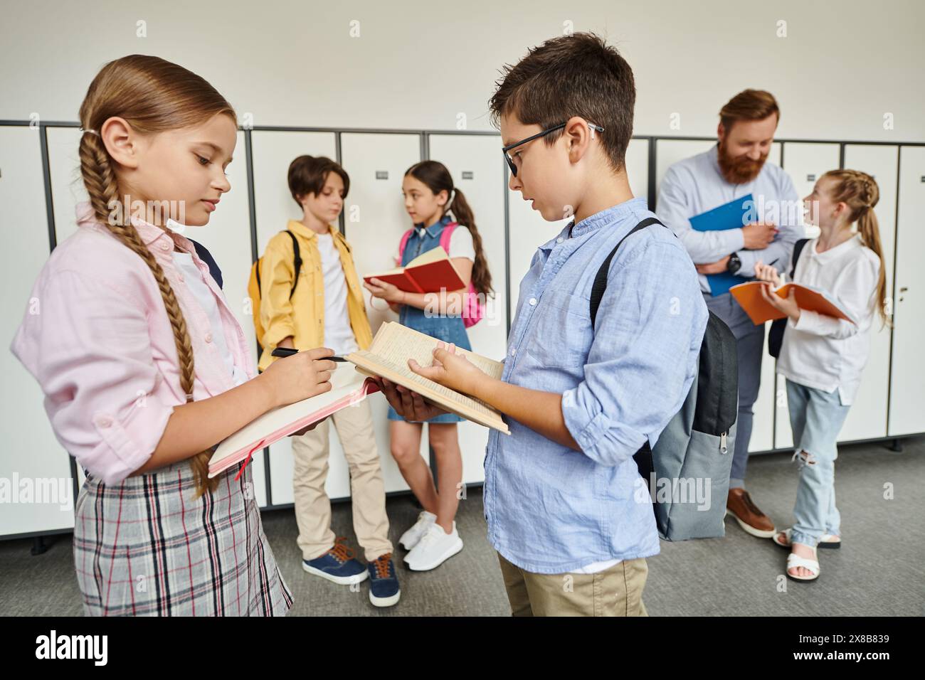 A diverse group of young kids, led by a male teacher, stand around each ...