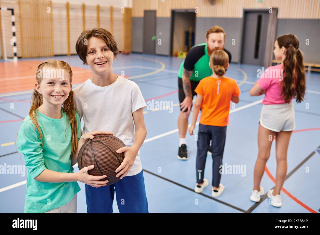 group of kids, including a man teacher, engaging in basketball ...