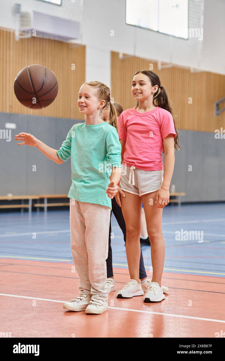 girls stand confidently atop a basketball court, listening attentively ...