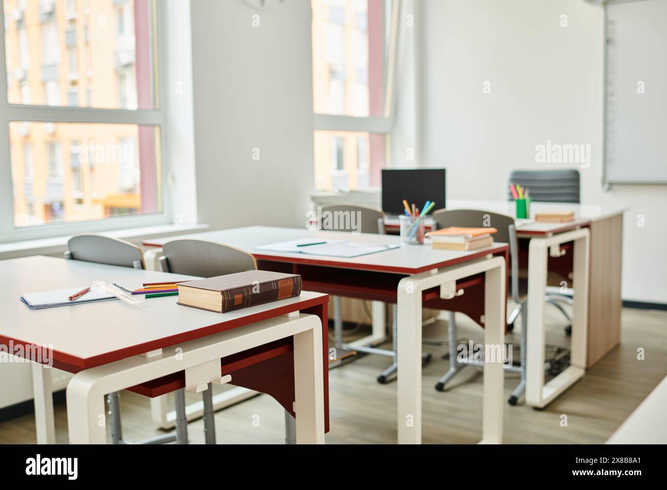 The classroom sits empty, desks and chairs aligned in neat rows Stock ...