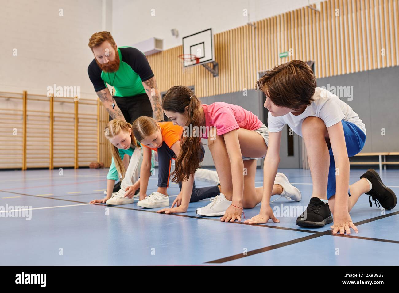 A diverse group of young people stand together on a blue floor as a ...