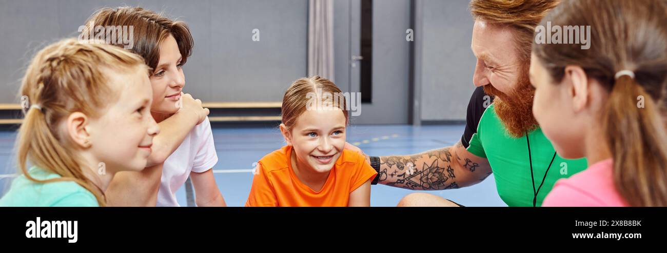 A man teacher is leading a diverse group of kids in an interactive ...