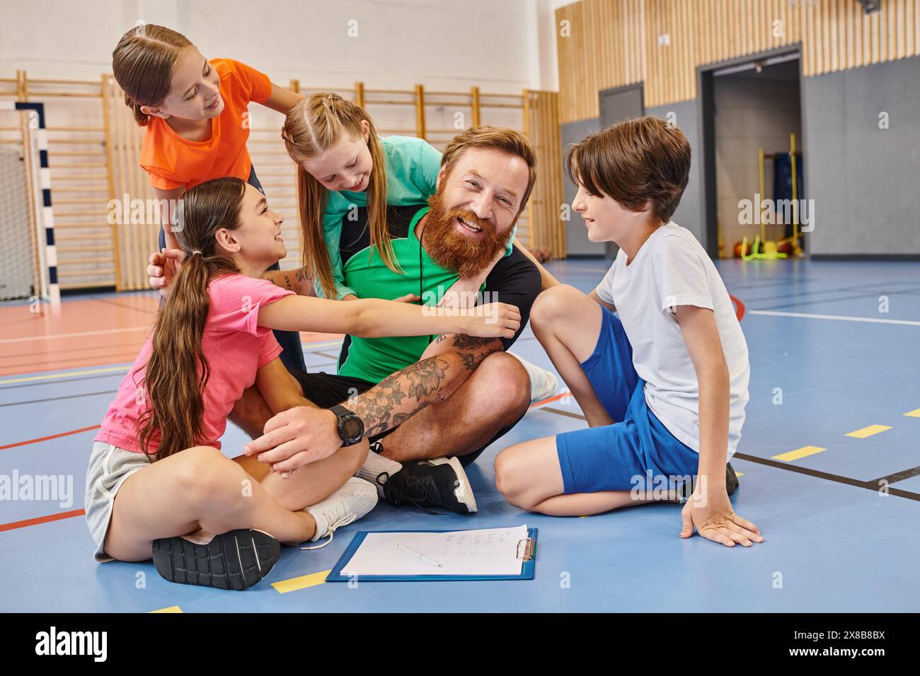 A man teacher sits on the floor surrounded by a diverse group of kids, engaging them in a lively ...