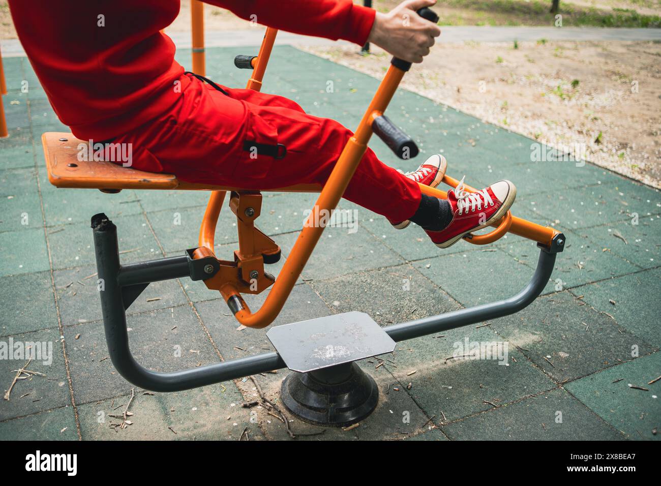 A male athlete works out on a street simulator in a park, performing an ...