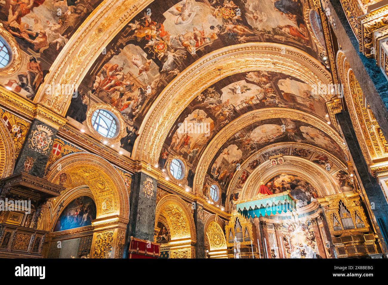 The interior of a cathedral, featuring a vaulted ceiling decorated with ...