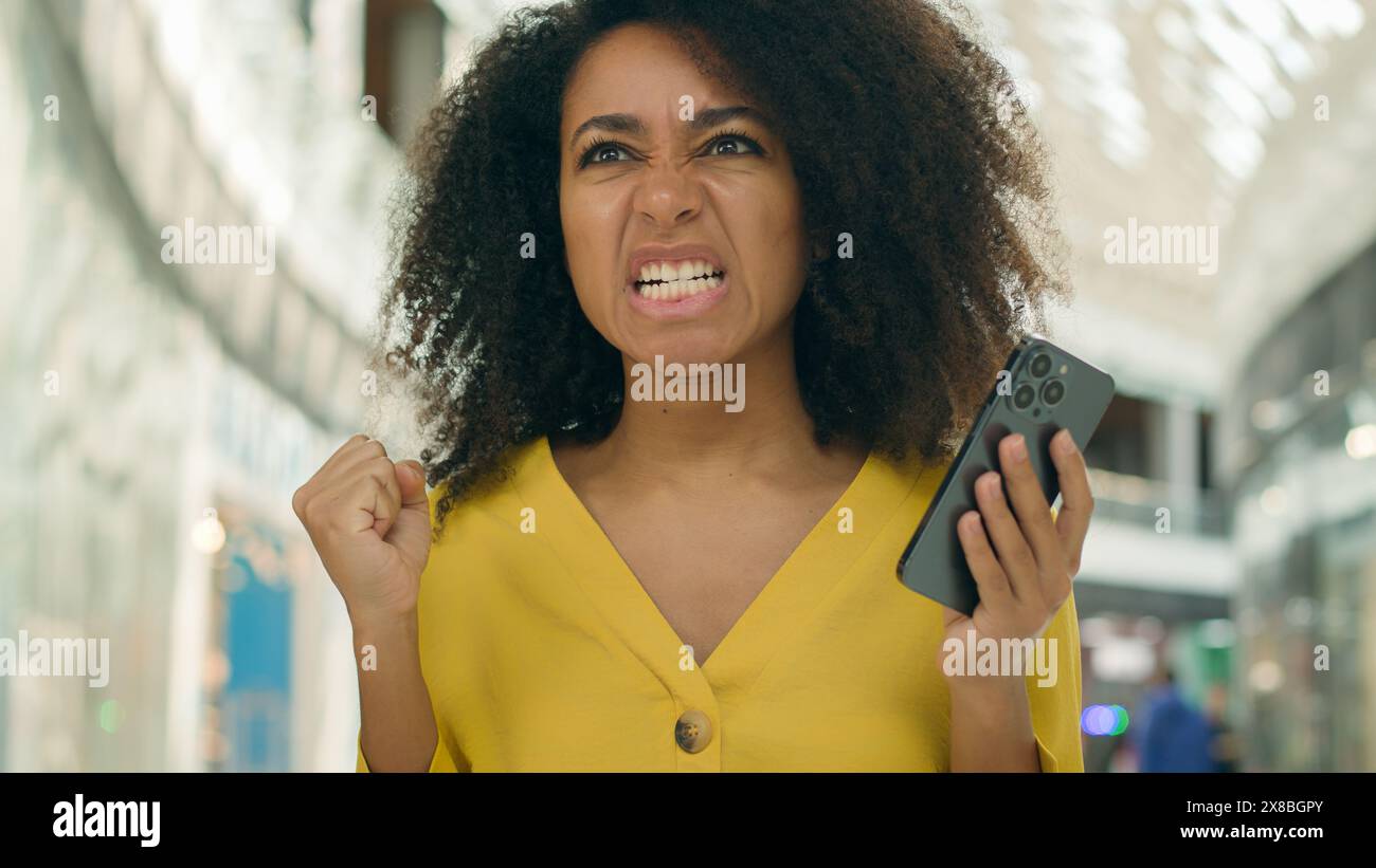Young unhappy African American woman looking at screen display ...