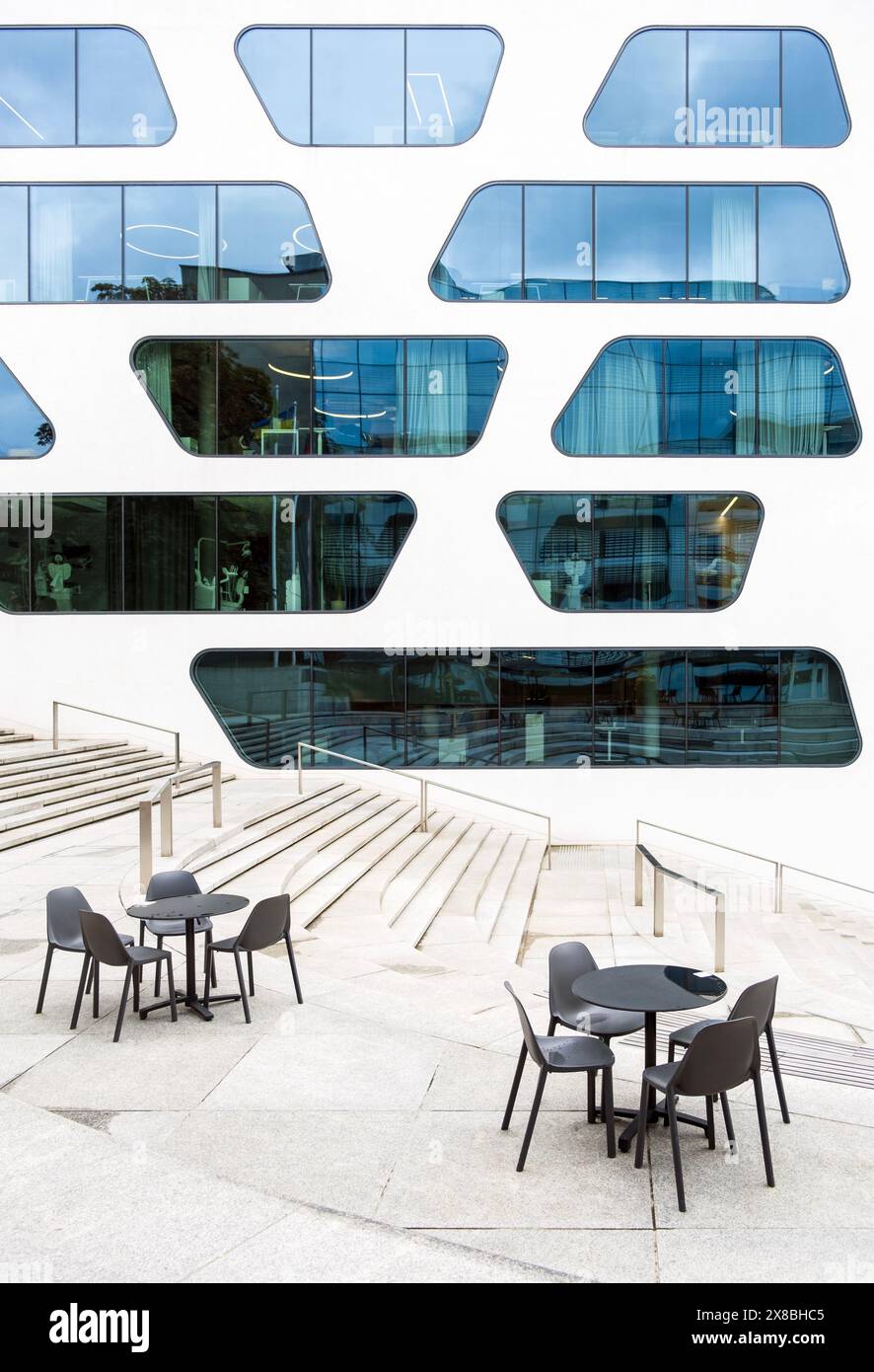 Empty cafe tables in front of modern office building, contemporary ...