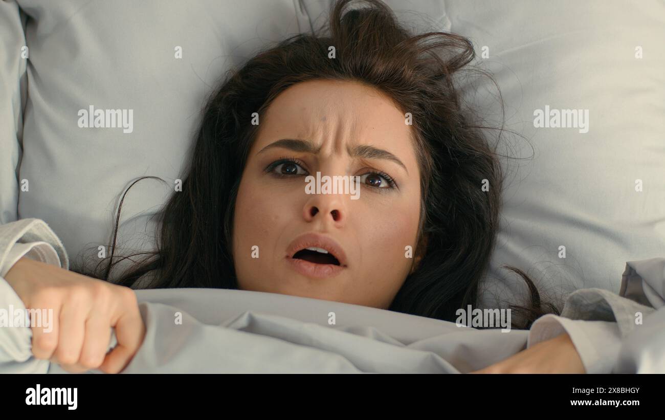 Close up woman unhappy girl female looking duvet blanket open mouth ...
