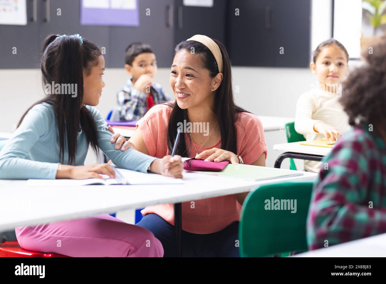 In school, in classroom, diverse family with children learning, mother ...
