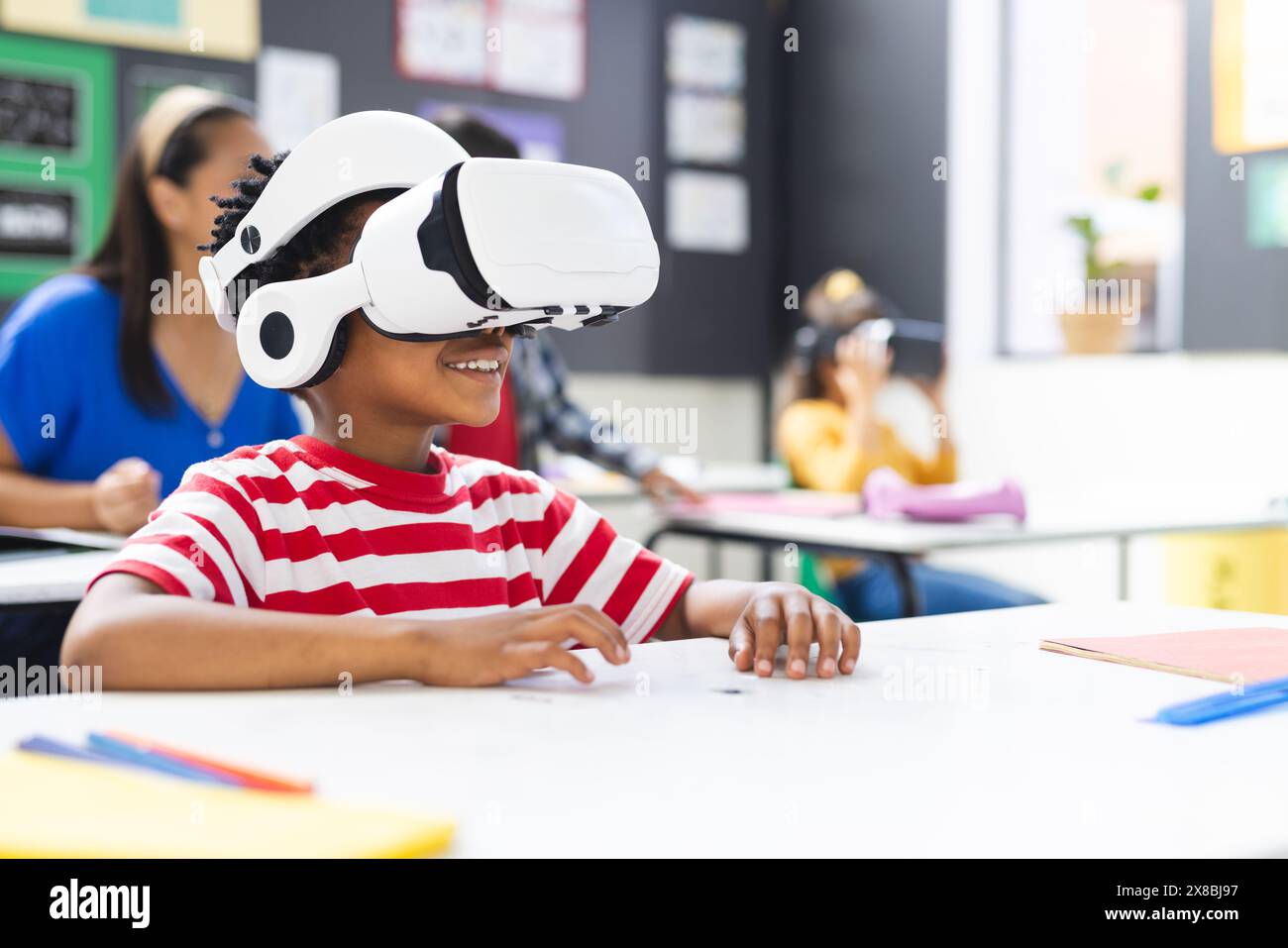 In school, young African American boy wearing a VR headset sits at a ...