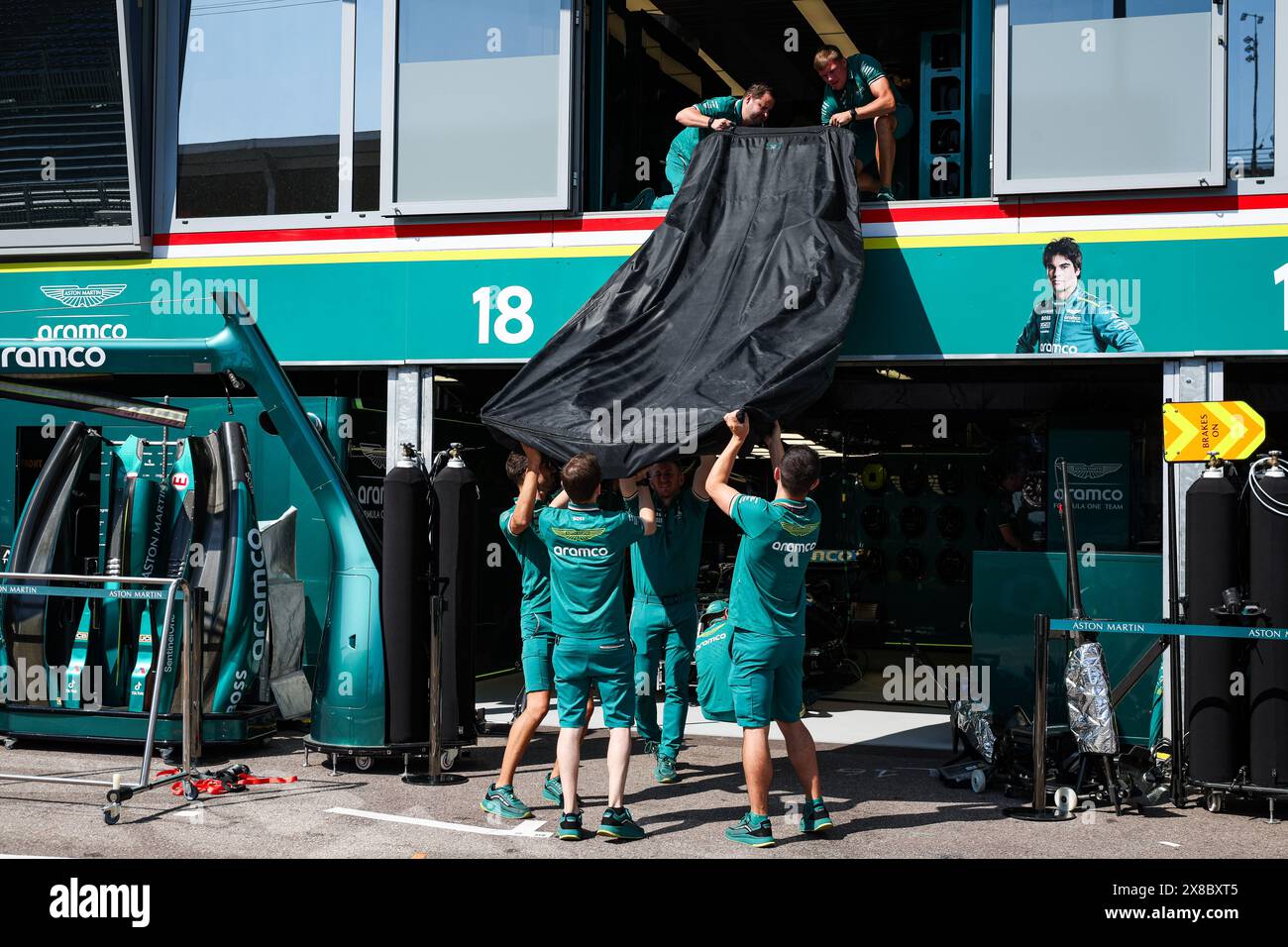 Aston Martin F1 Team mechanics carrying a floor on the top of the ...