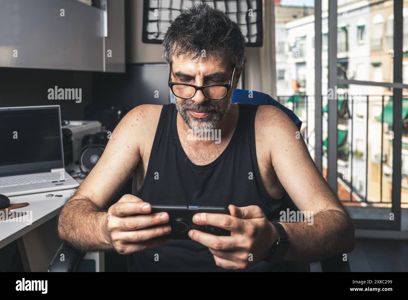 Connected man, managing his business from the comfort of his home ...