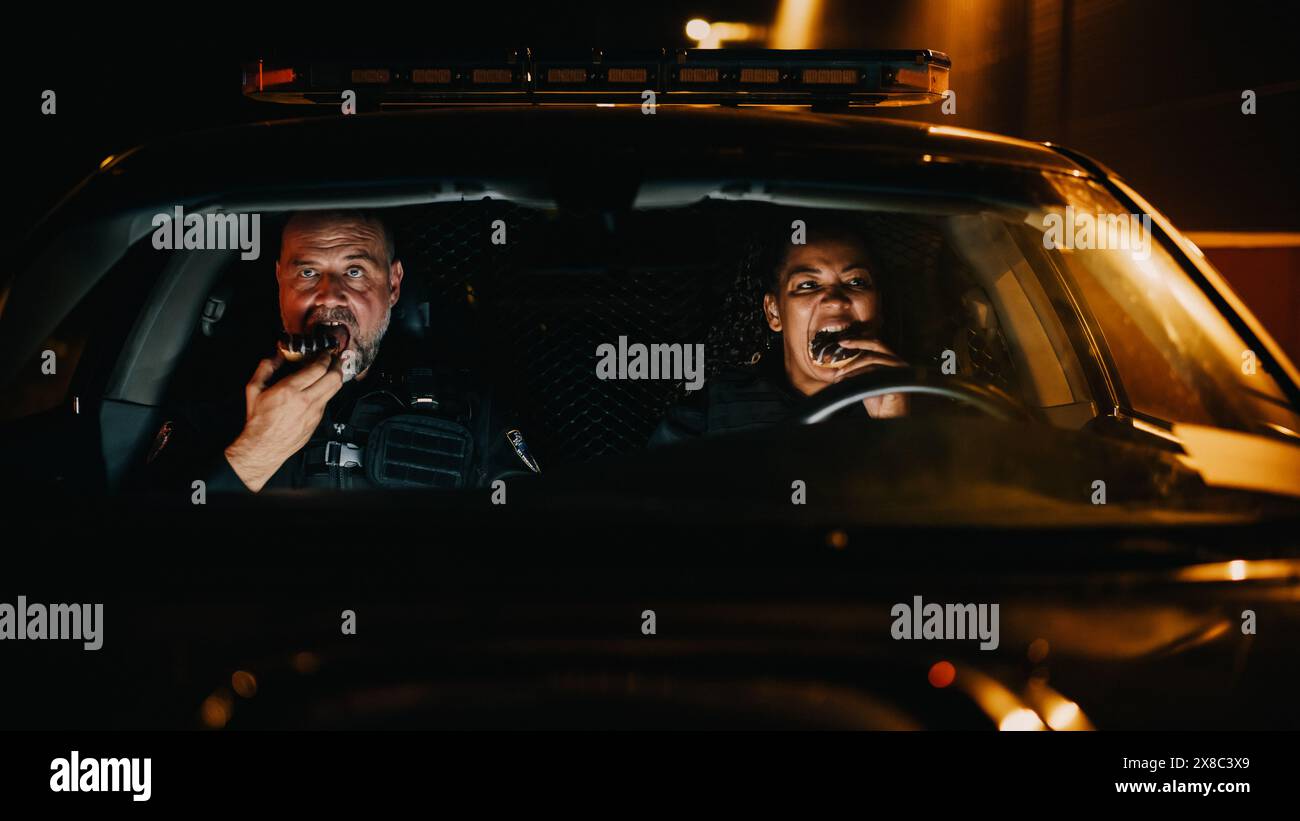 Two Police Officers Sitting in Traffic Patrol Car, Eating Donuts ...