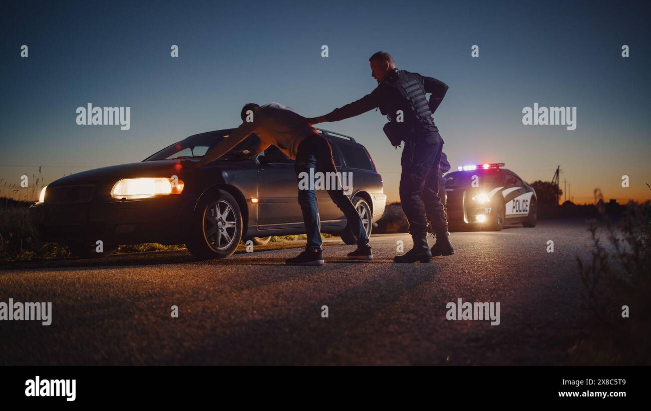 A Professional Middle Aged Policeman Performing a Pat-Down Search on a ...