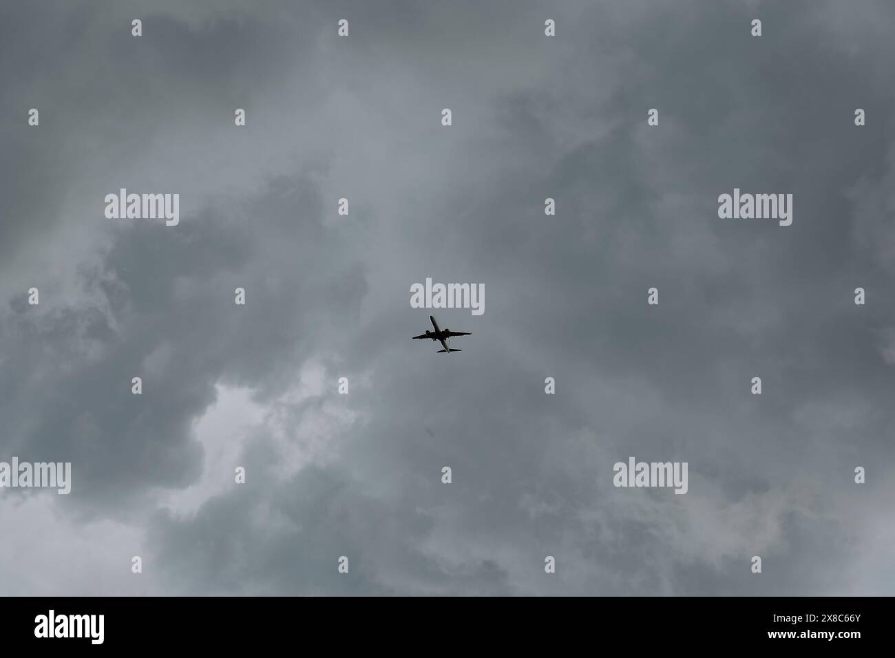 A plane is seen lewering under dark storm clouds as a storm with strong ...