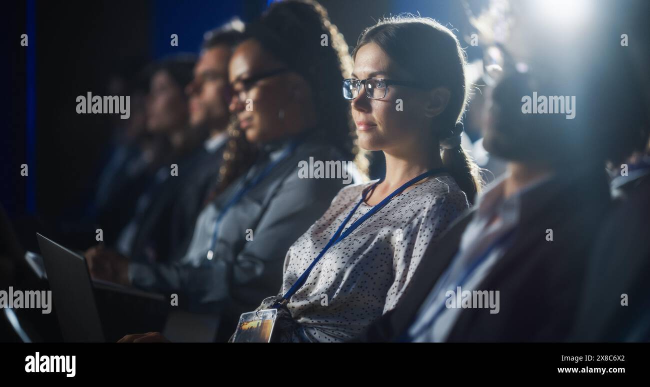 Crowd of Smart Tech People in Dark Conference Hall Watching an Innovative Inspiring Keynote ...