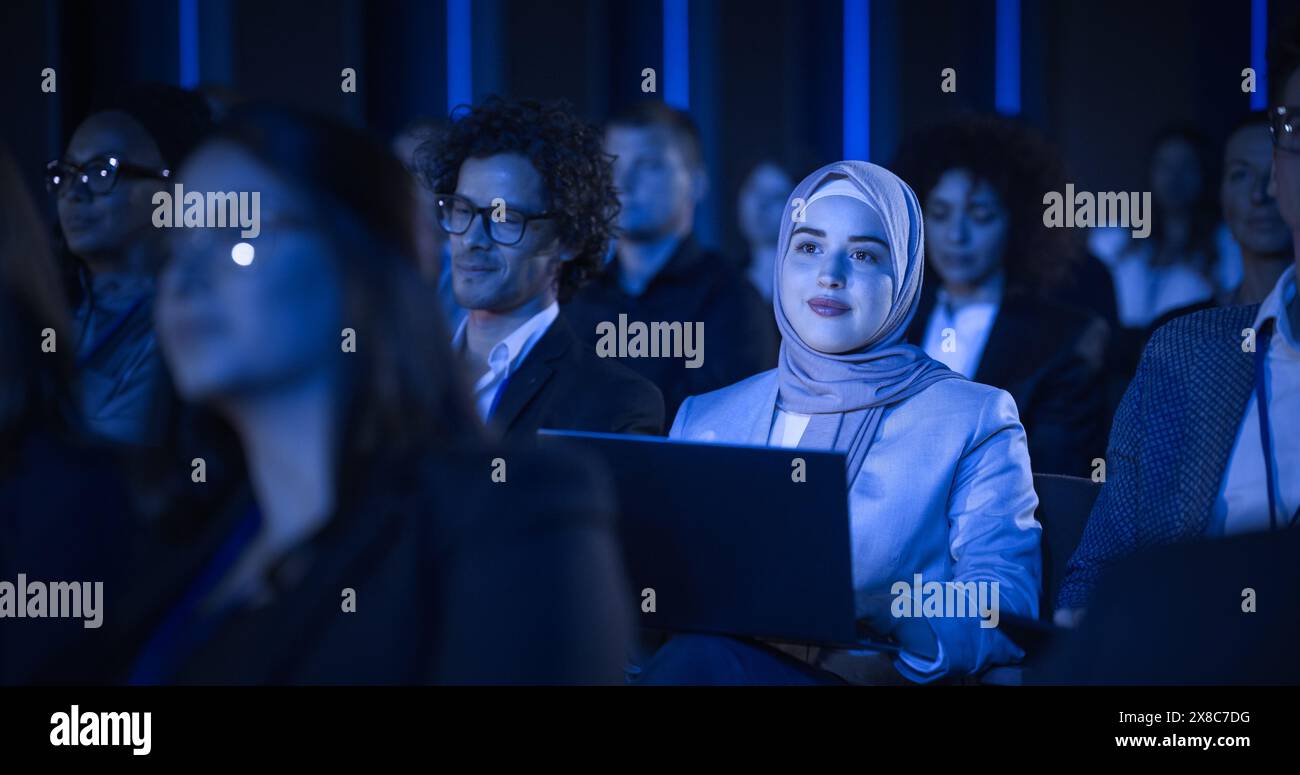 Arab Female Sitting in a Dark Crowded Auditorium at a Tech Conference ...