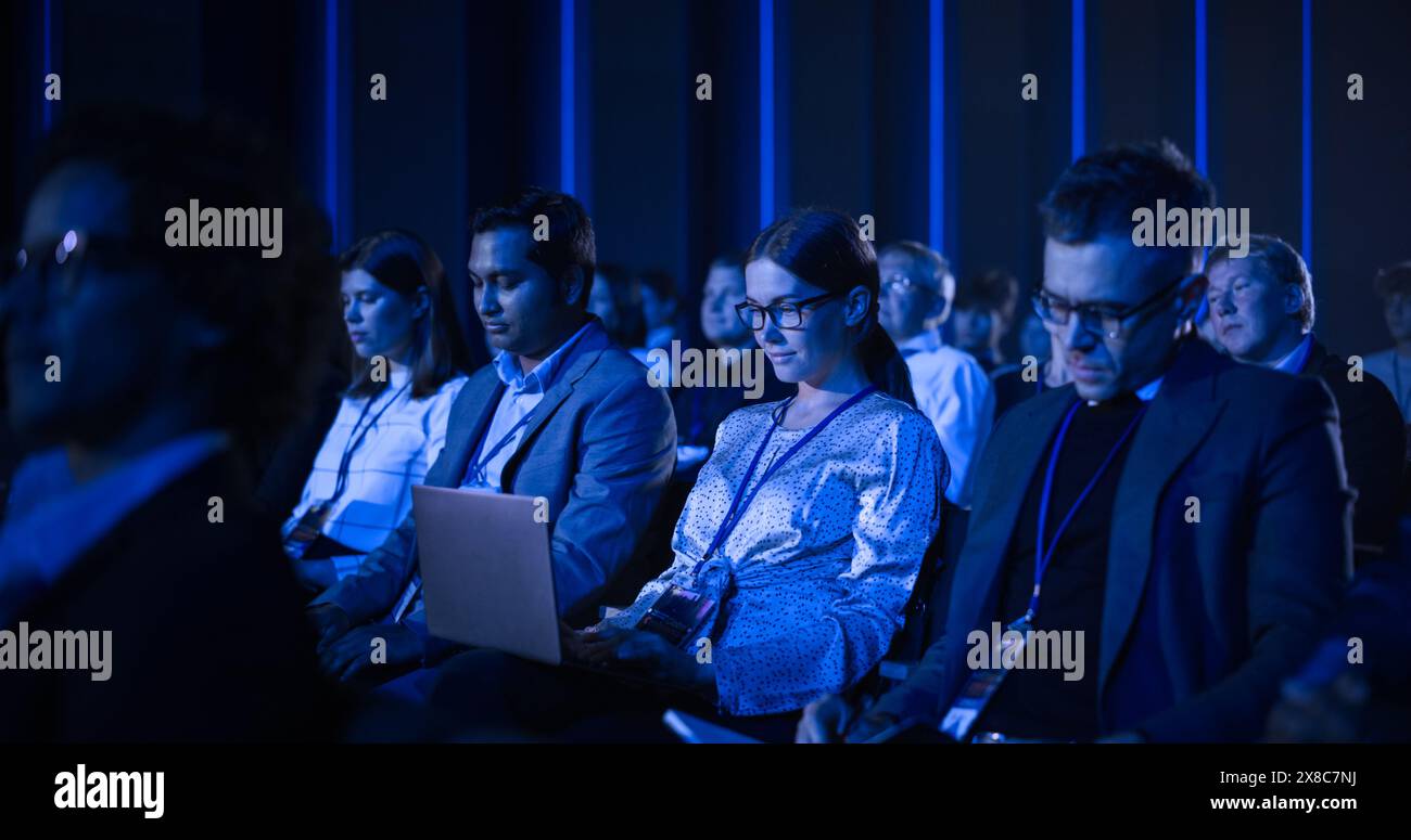 Female Sitting in a Dark Crowded Auditorium at a Tech Conference. Young ...