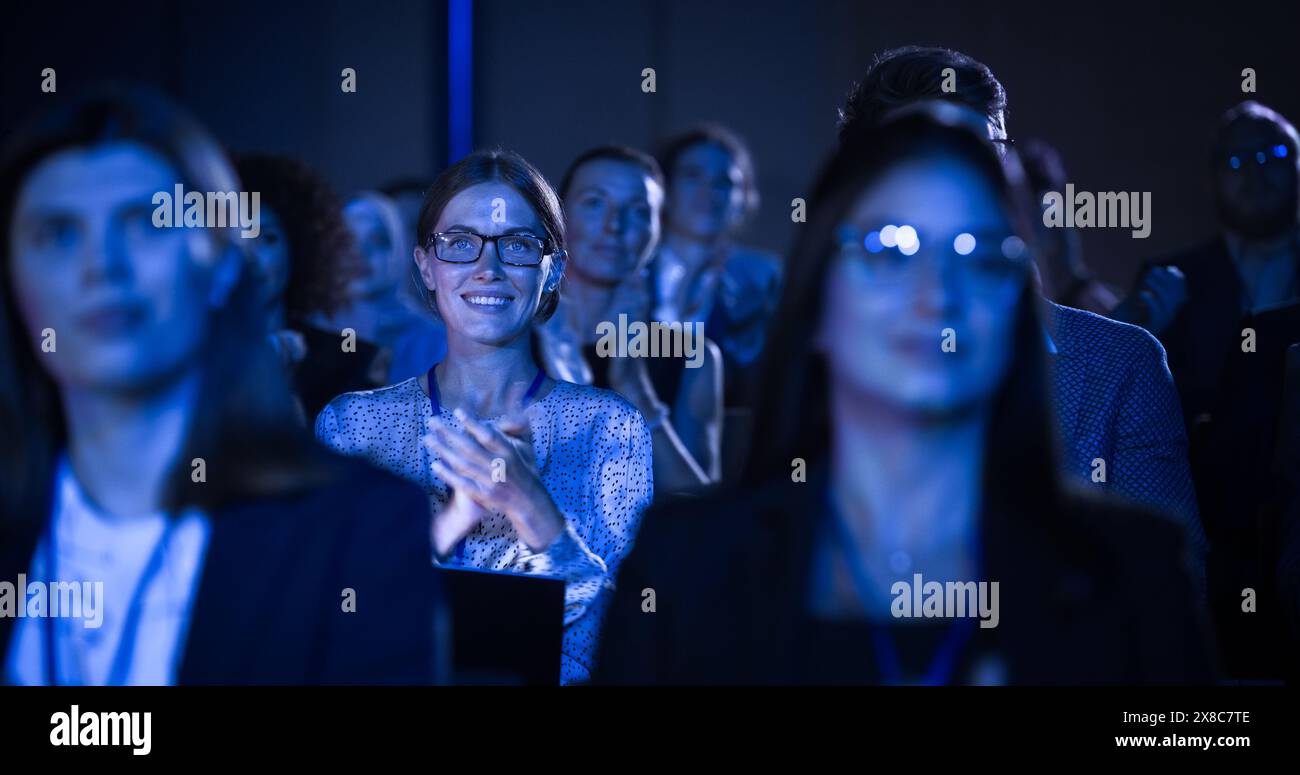 Beautiful Female Sitting in a Dark Crowded Auditorium at a Conference ...