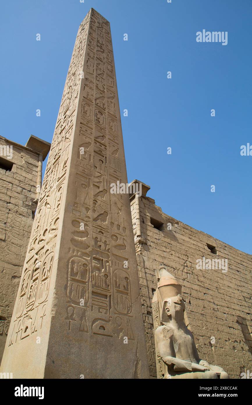 Obelisk (foreground), Colossus of Ramses II (background), Luxor Temple ...