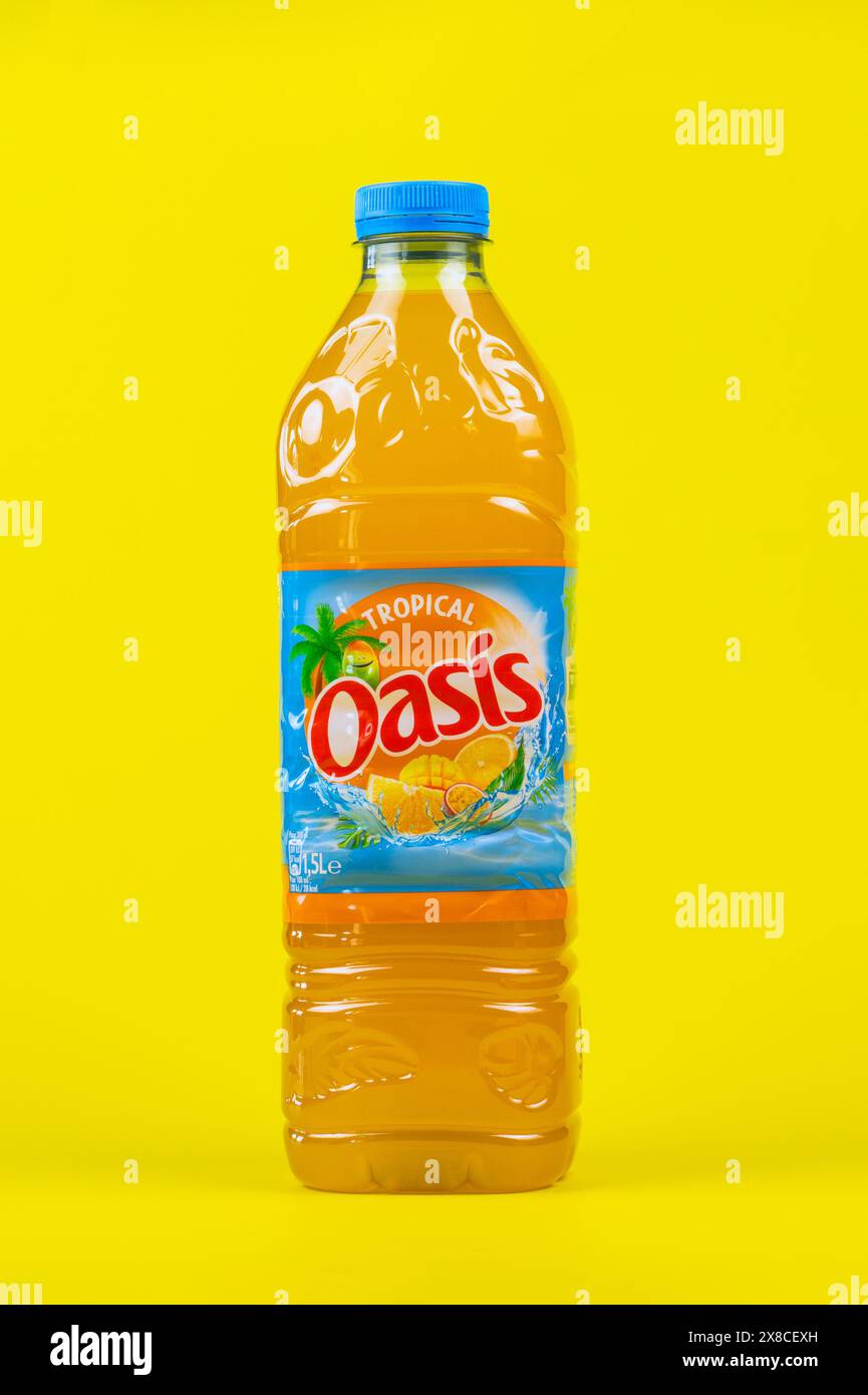 bottle of Oasis brand tropical flavor fruit drink, isolated on a yellow ...