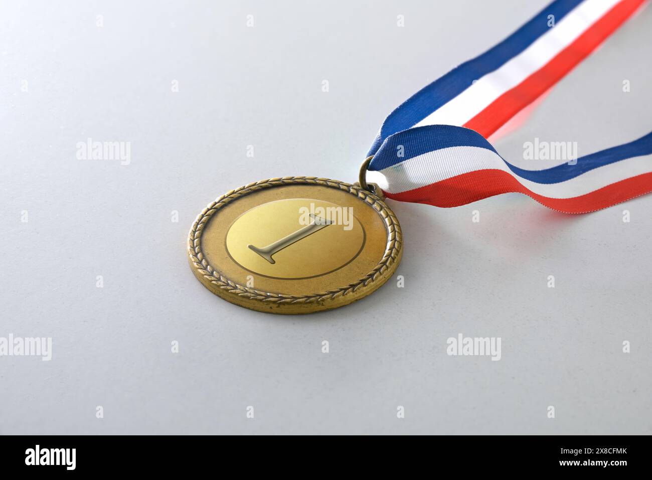 Golden metal medal with engraved number one and ribbon with blue white ...