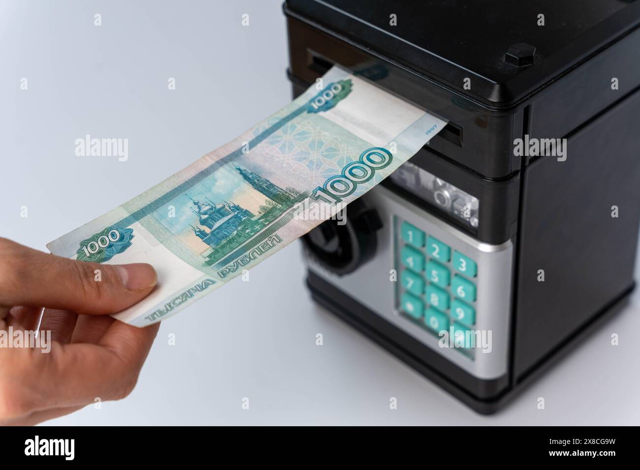 Individual inserting cash into automated teller machine Stock Photo - Alamy