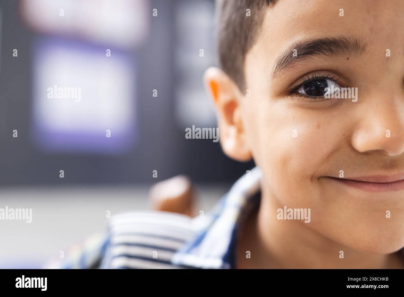 In school, in the classroom, a young biracial boy with a cheerful ...
