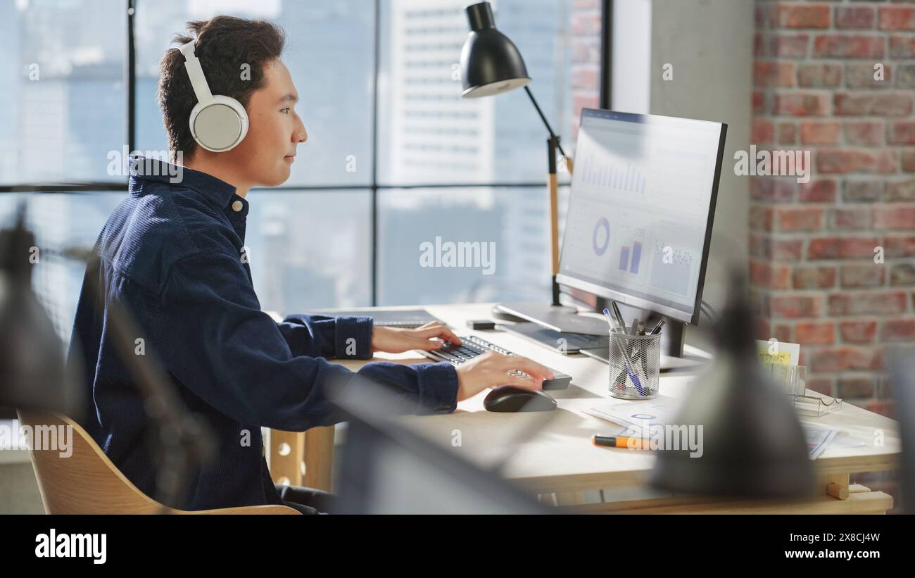 Profile View of a Portrait of an Asian Young Man Working on a Computer ...