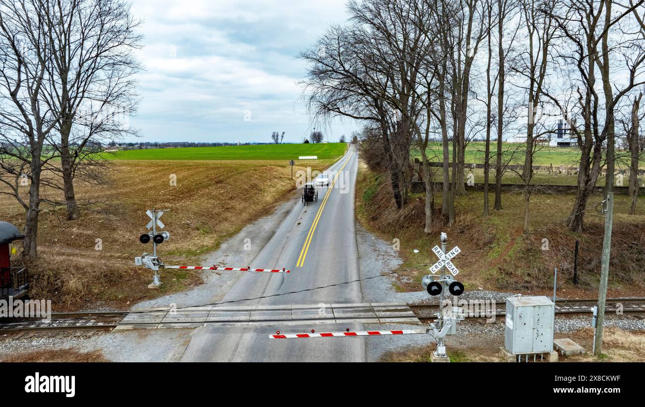 A Rural Road with An Amish Horse-Drawn Carriage at Railroad Crossing ...