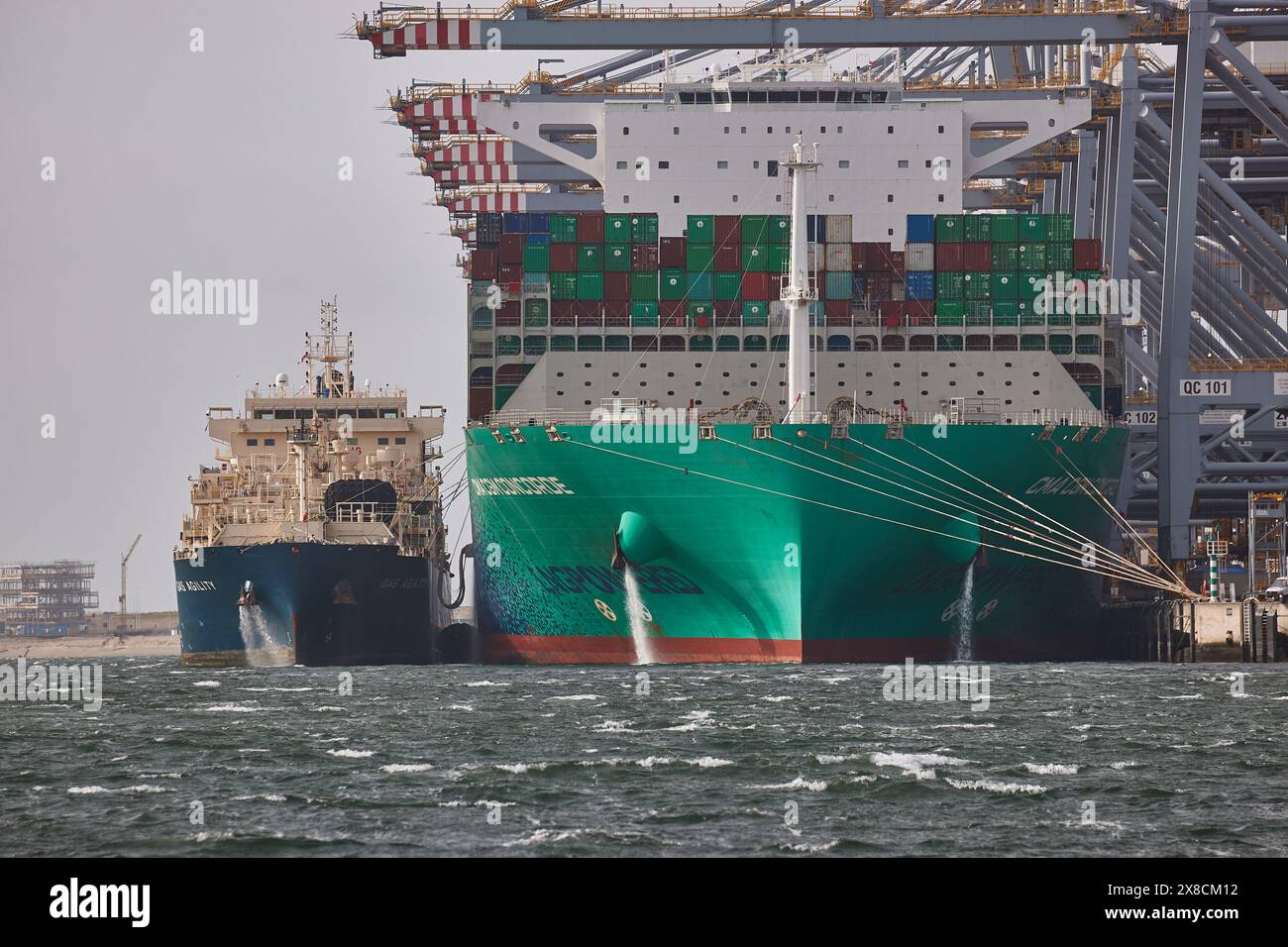 Loading containers on a huge cargo ship Stock Photo - Alamy