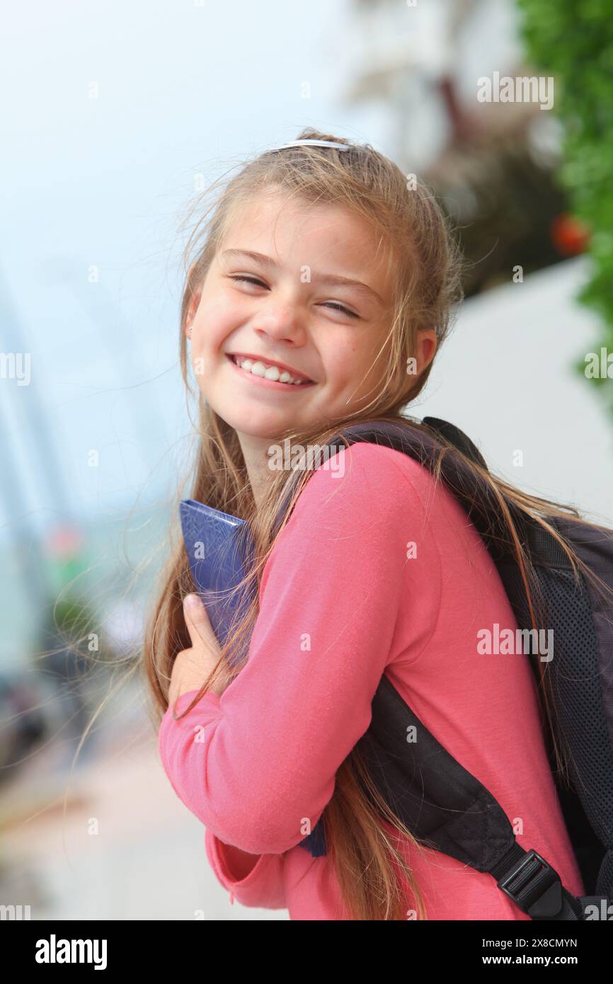 cheerful elementary schoolgirl on white background Stock Photo - Alamy