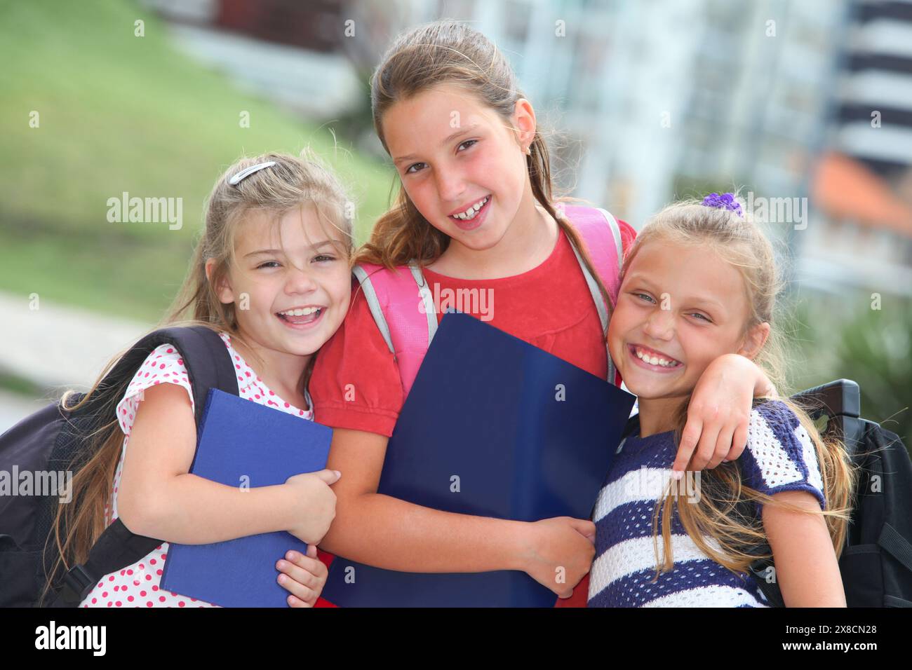 portrait of three cheerful elementary schoolgirls outdoors Stock Photo ...